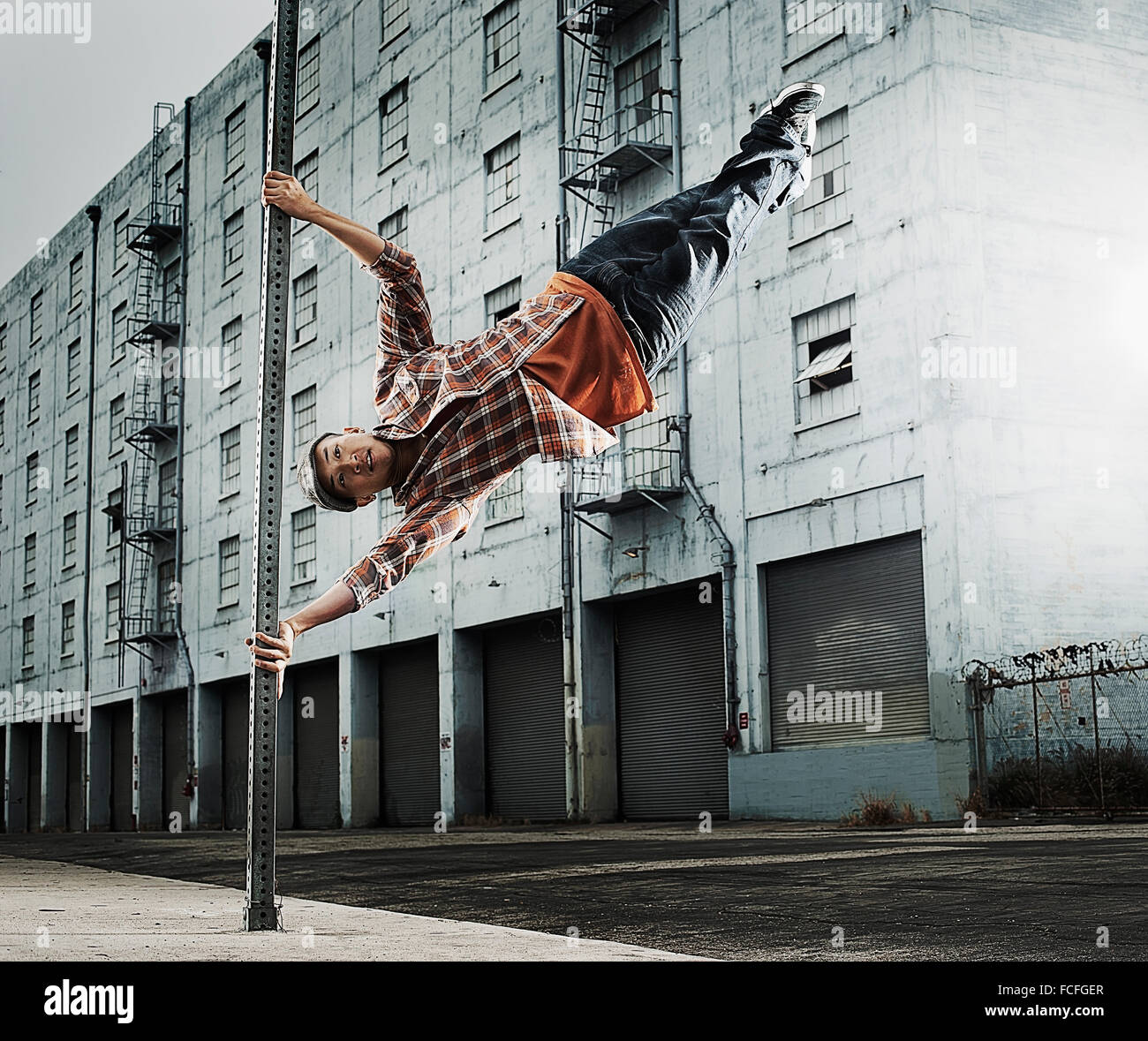 A young man breakdancing, leaping in the air, and stretching out Stock ...