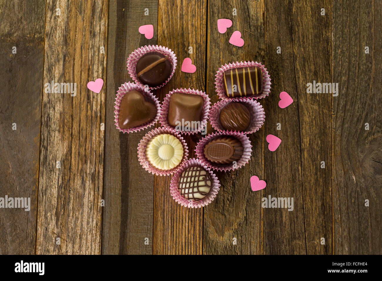Assorted chocolates on rustic wood table Stock Photo - Alamy