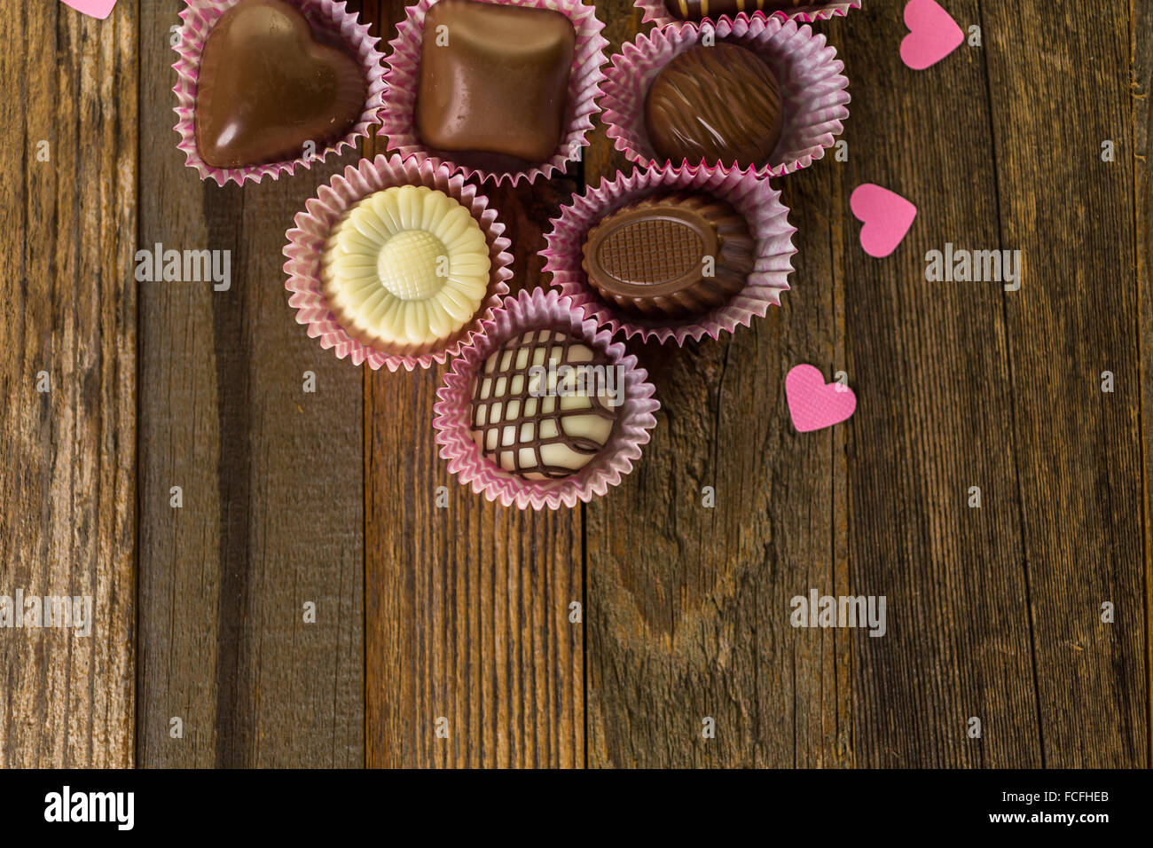 Assorted chocolates on rustic wood table Stock Photo - Alamy