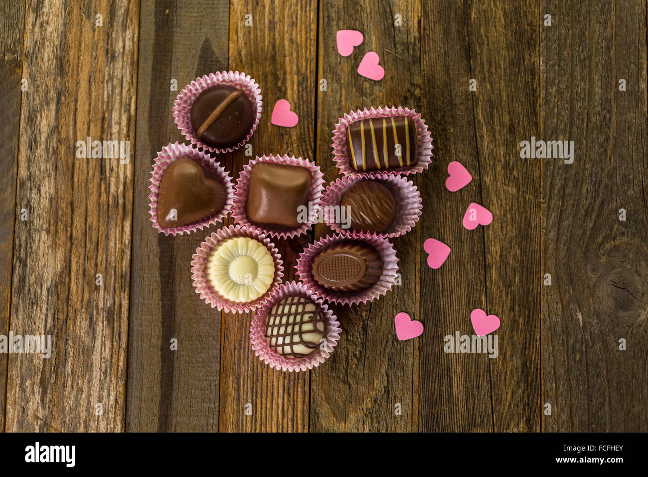 Assorted chocolates on rustic wood table Stock Photo - Alamy