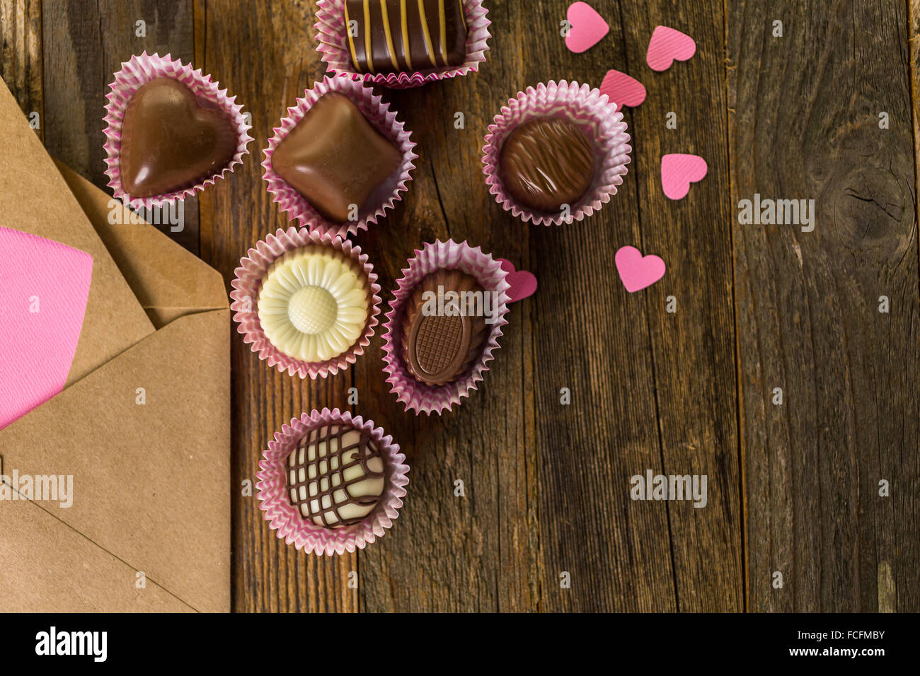 Assorted chocolates on rustic wood table Stock Photo - Alamy