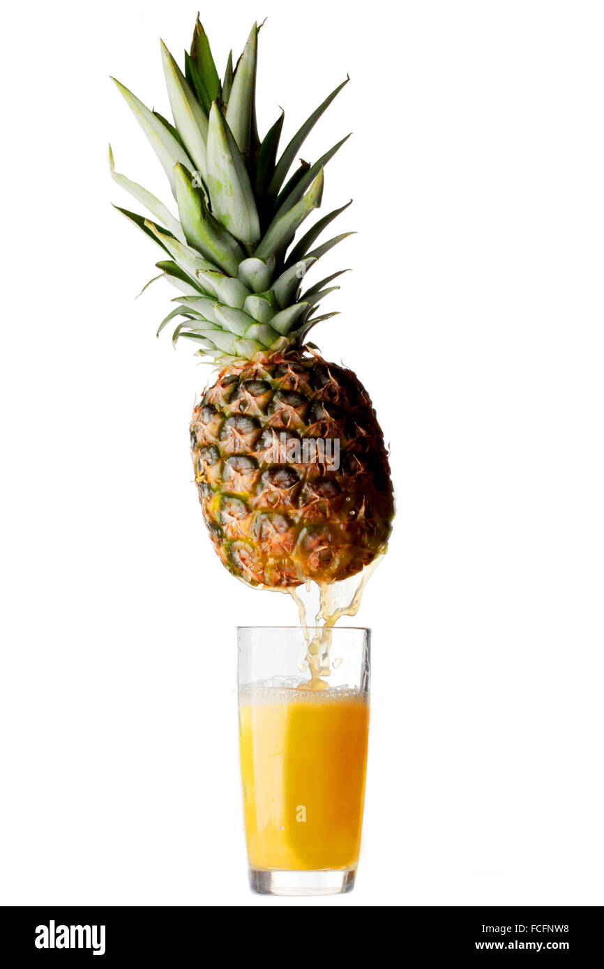 Juice pouring from pineapple into glass isolated on white background ...