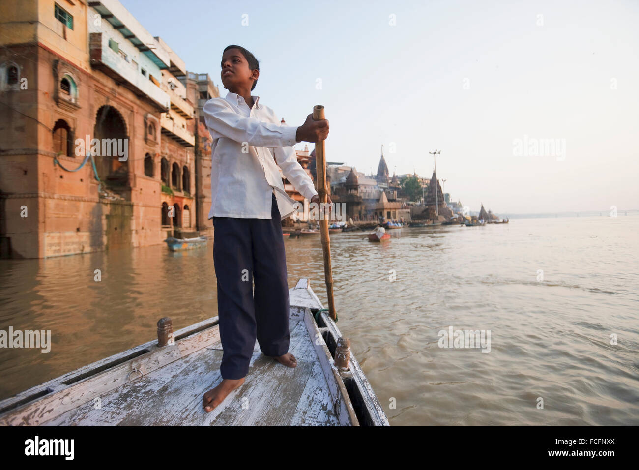 Boy rowing a boat on Ganges River, Varanasi, India Stock Photo - Alamy
