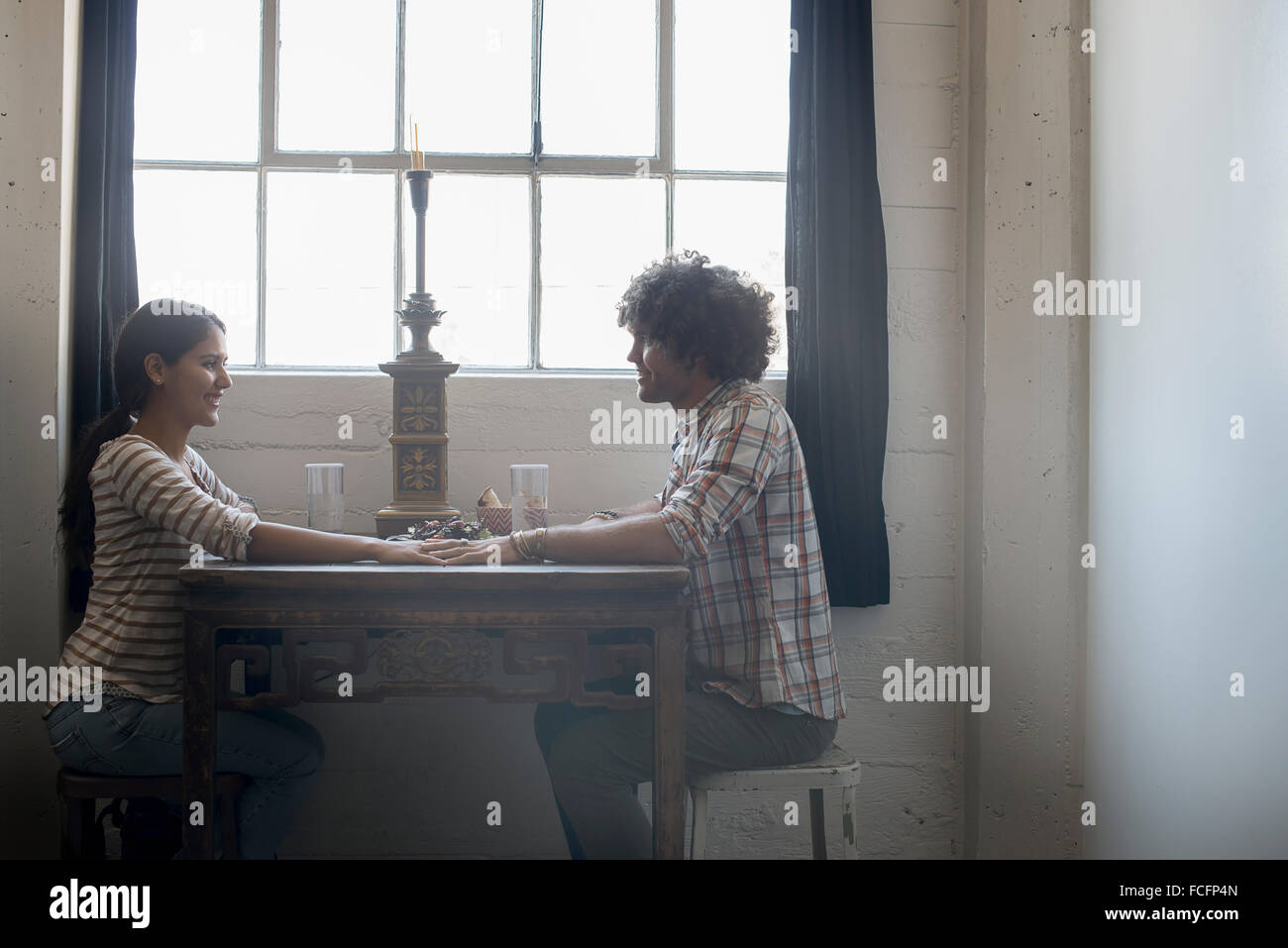 Couple holding hands across the table hi-res stock photography and ...