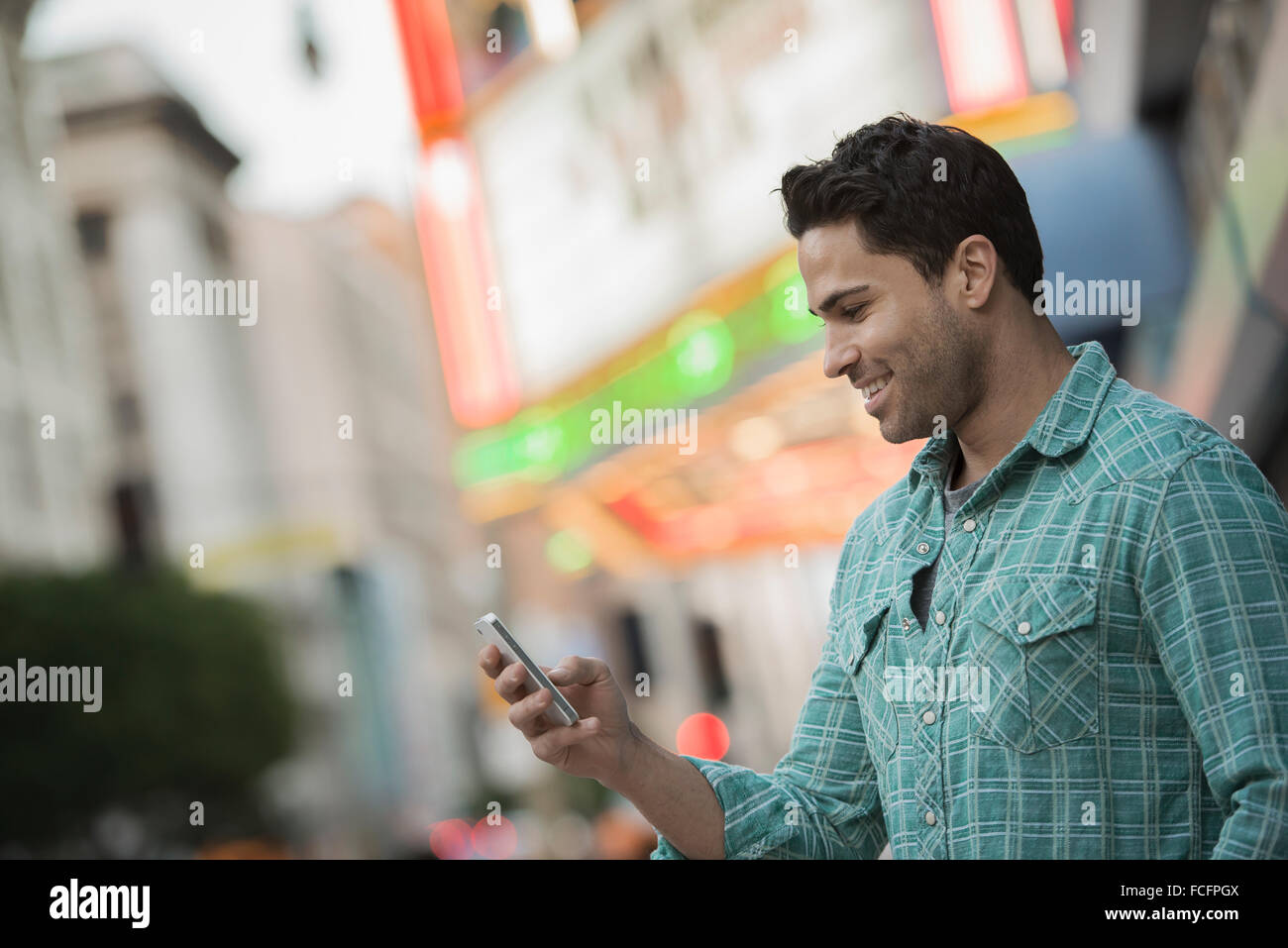 A man checking his phone on a city street Stock Photo - Alamy