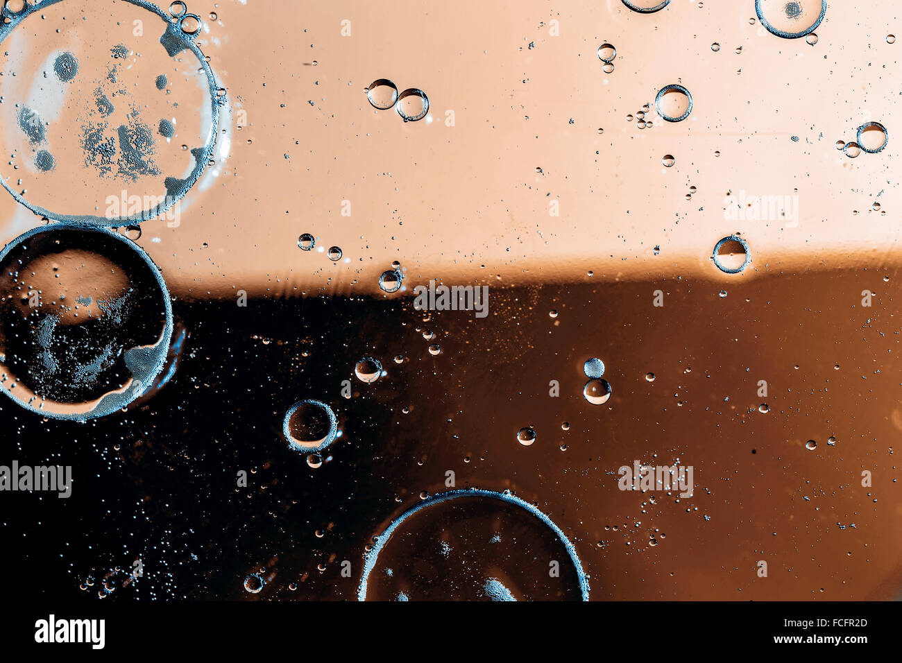Oil drops on a water surface with color background Stock Photo - Alamy