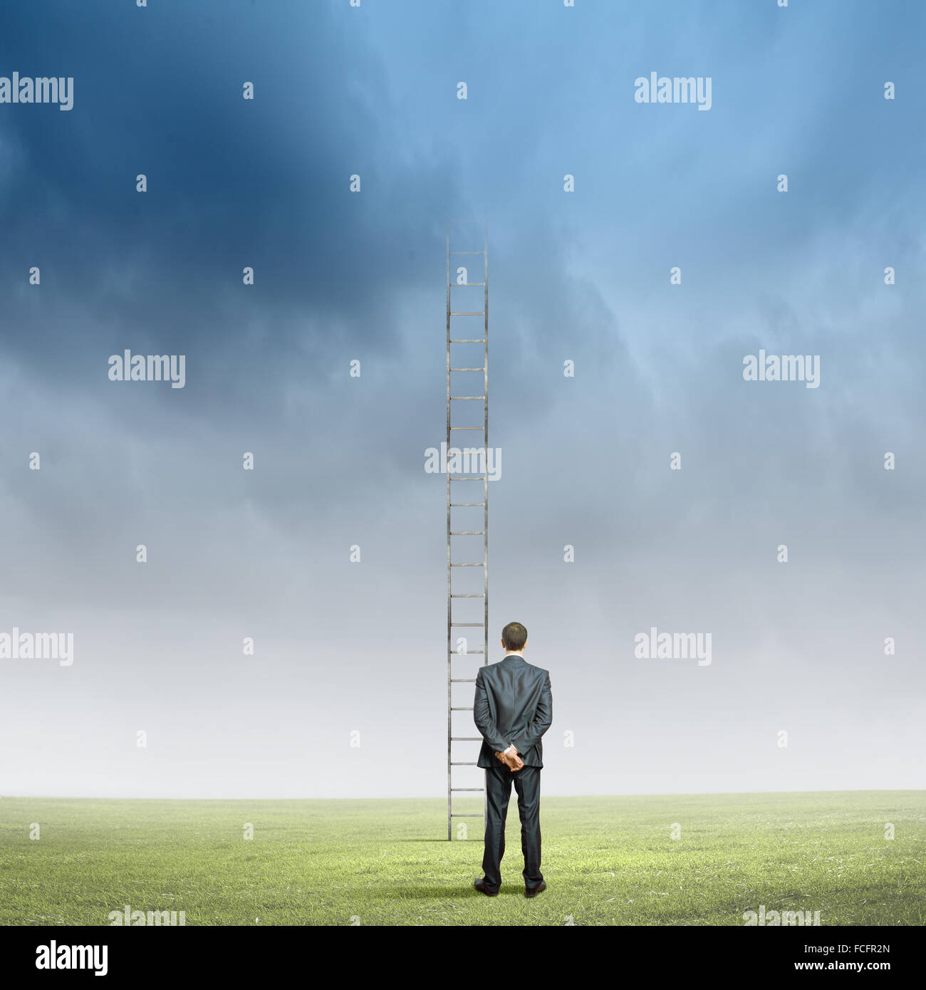 Rear view of businessman standing near ladder going high in sky Stock ...