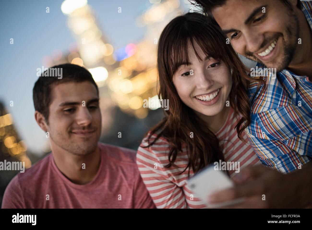 A small group of friends gathered on a rooftop terrace overlooking a ...