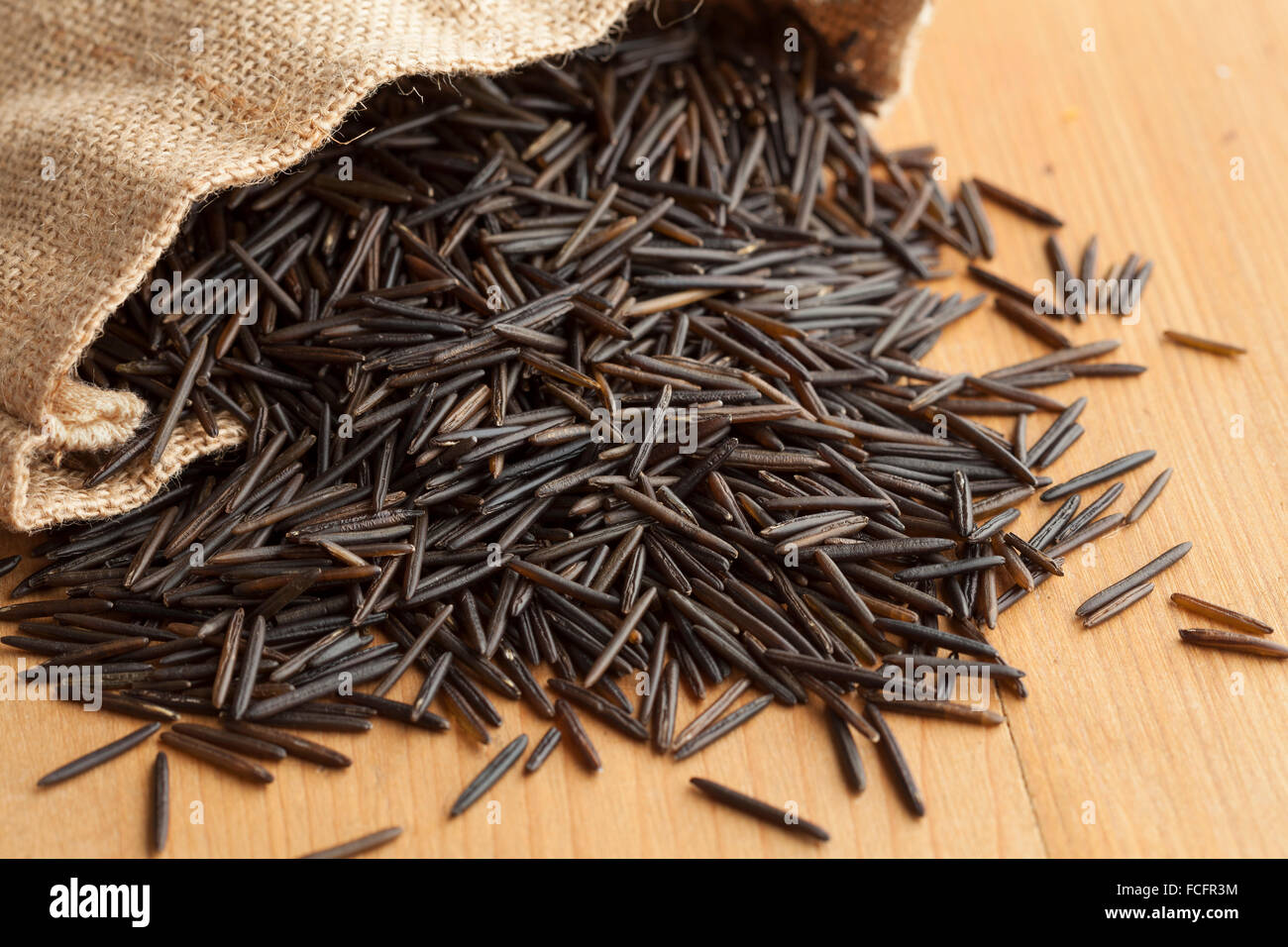 Raw black wild rice from a jute bag Stock Photo - Alamy