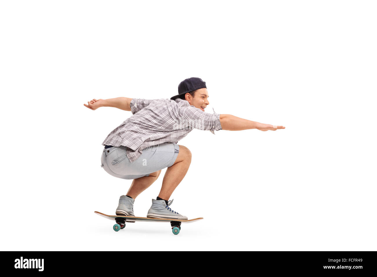Studio shot of a young man riding a skateboard isolated on white ...