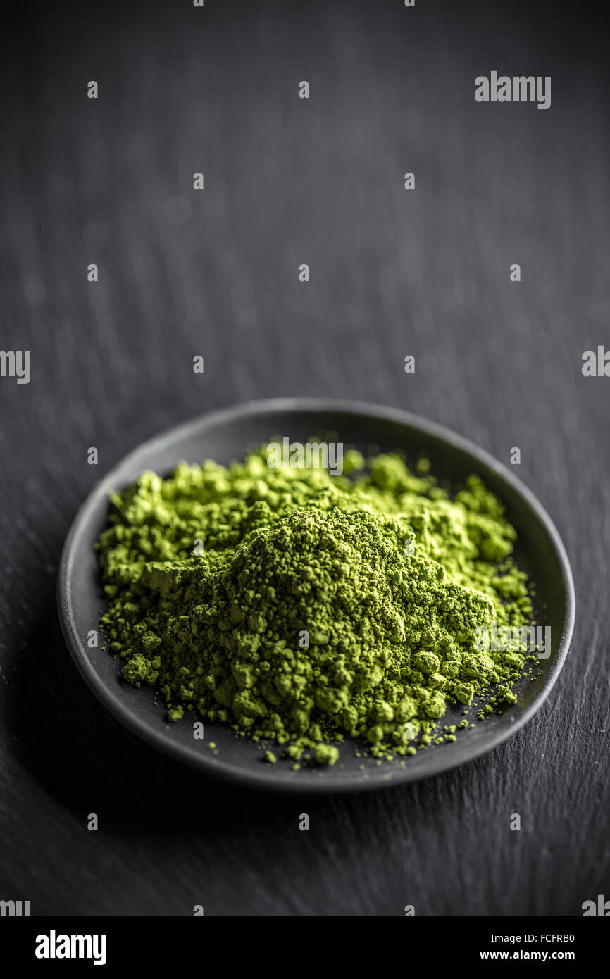 Powder green tea, matcha in black plate Stock Photo - Alamy