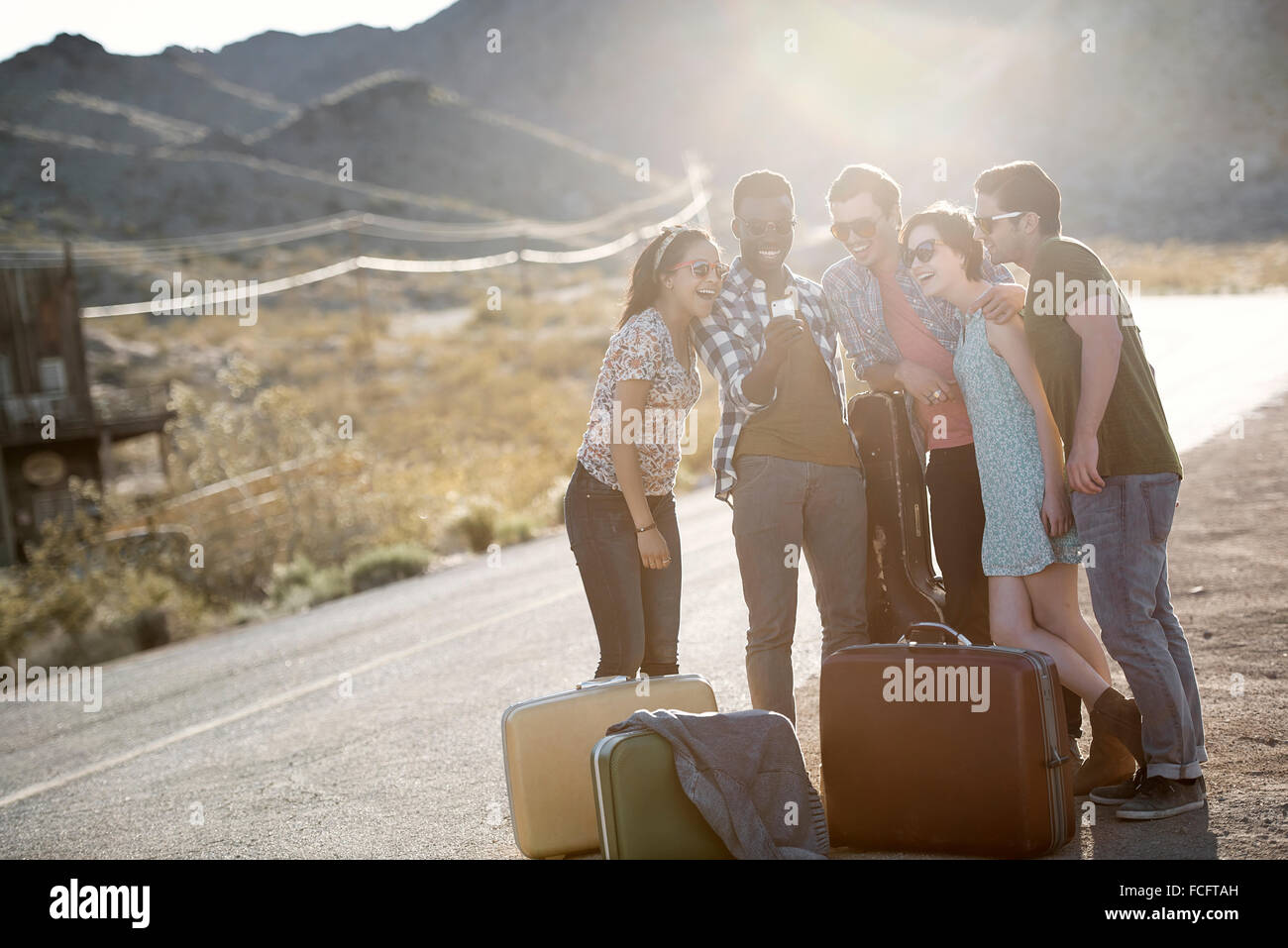 A group of people, men and women, on the road with cases, in open ...