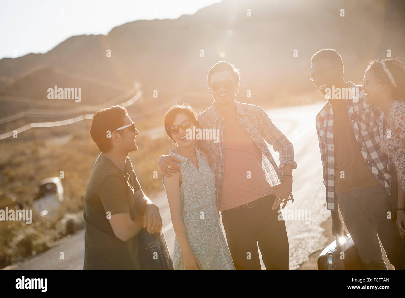 A group of people, men and women, on the road with cases, in open ...