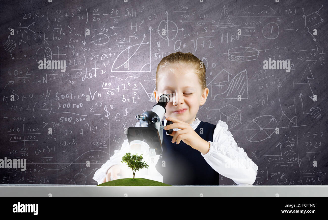 Cute schoolgirl at school lesson using microscope Stock Photo - Alamy