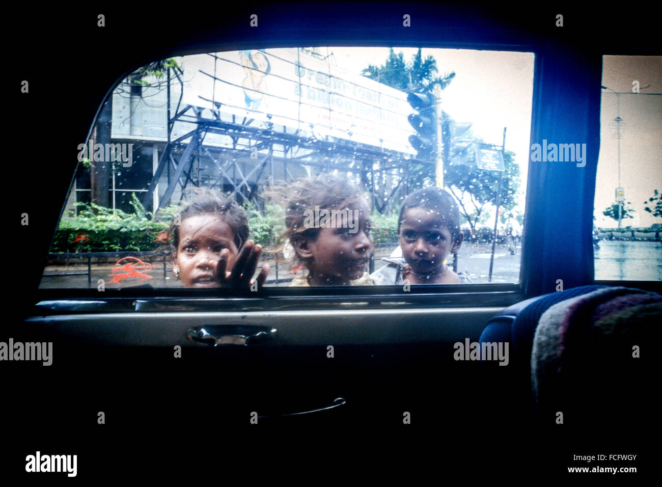 Street children begging at the window of a taxi in Mumbai, or Bombay ...