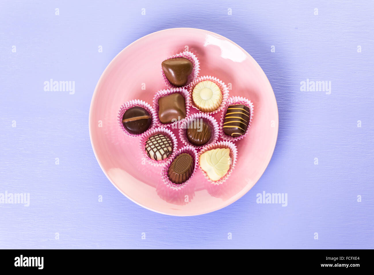 Assorted chocolates on pink plate Stock Photo - Alamy