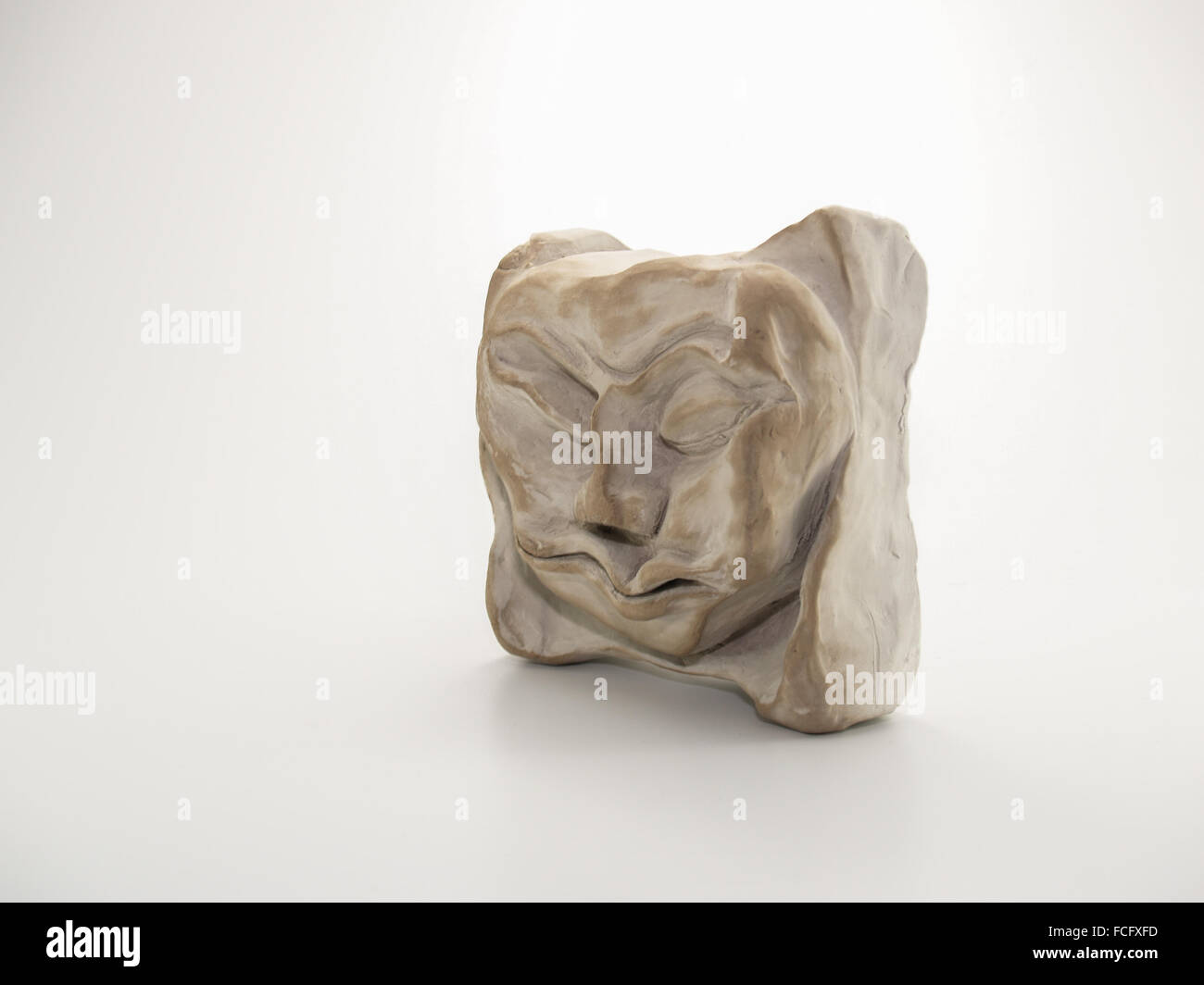 Clay sculpture of angry sleeping scrunched up face on white background ...