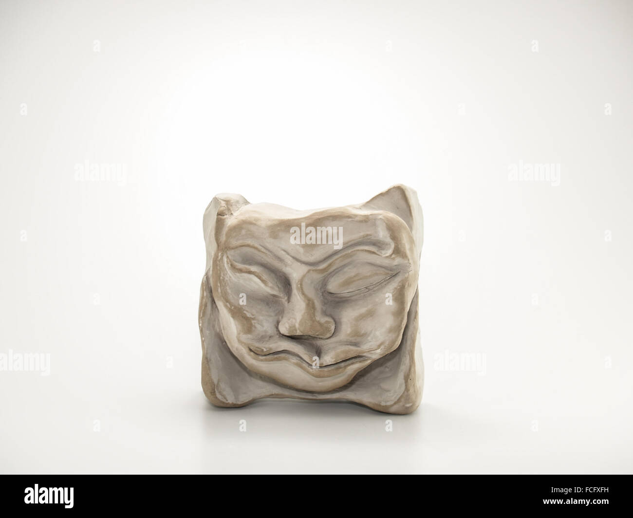 Clay sculpture of angry sleeping scrunched up face on white background ...