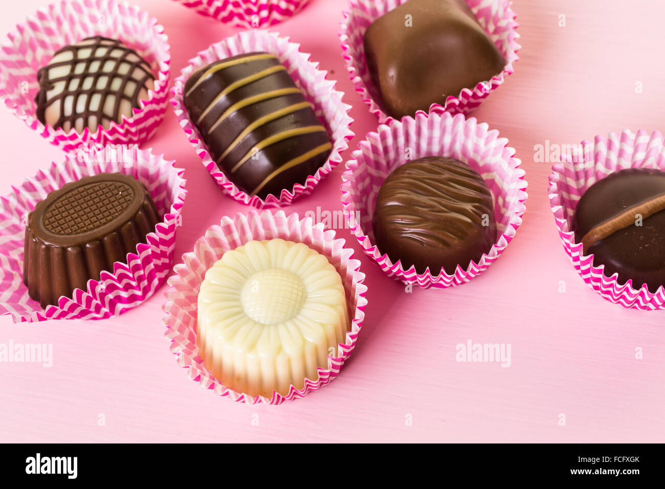 Assorted chocolates on pink background Stock Photo - Alamy
