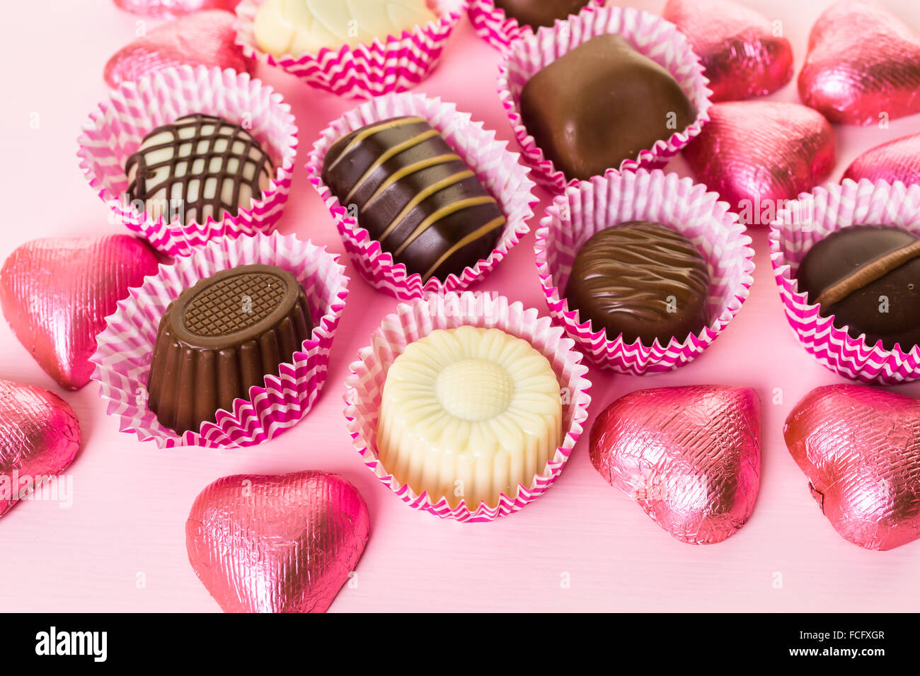 Assorted chocolates on pink background Stock Photo - Alamy