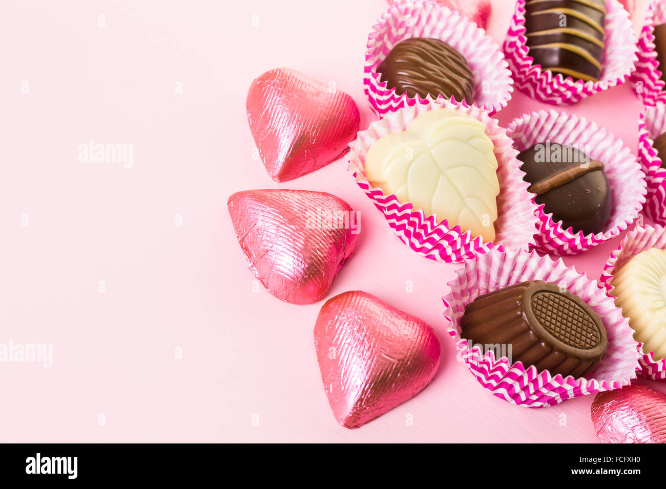 Assorted chocolates on pink background Stock Photo - Alamy