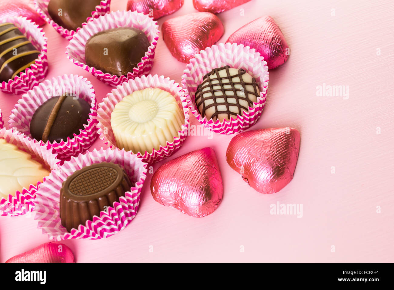 Assorted chocolates on pink background Stock Photo - Alamy