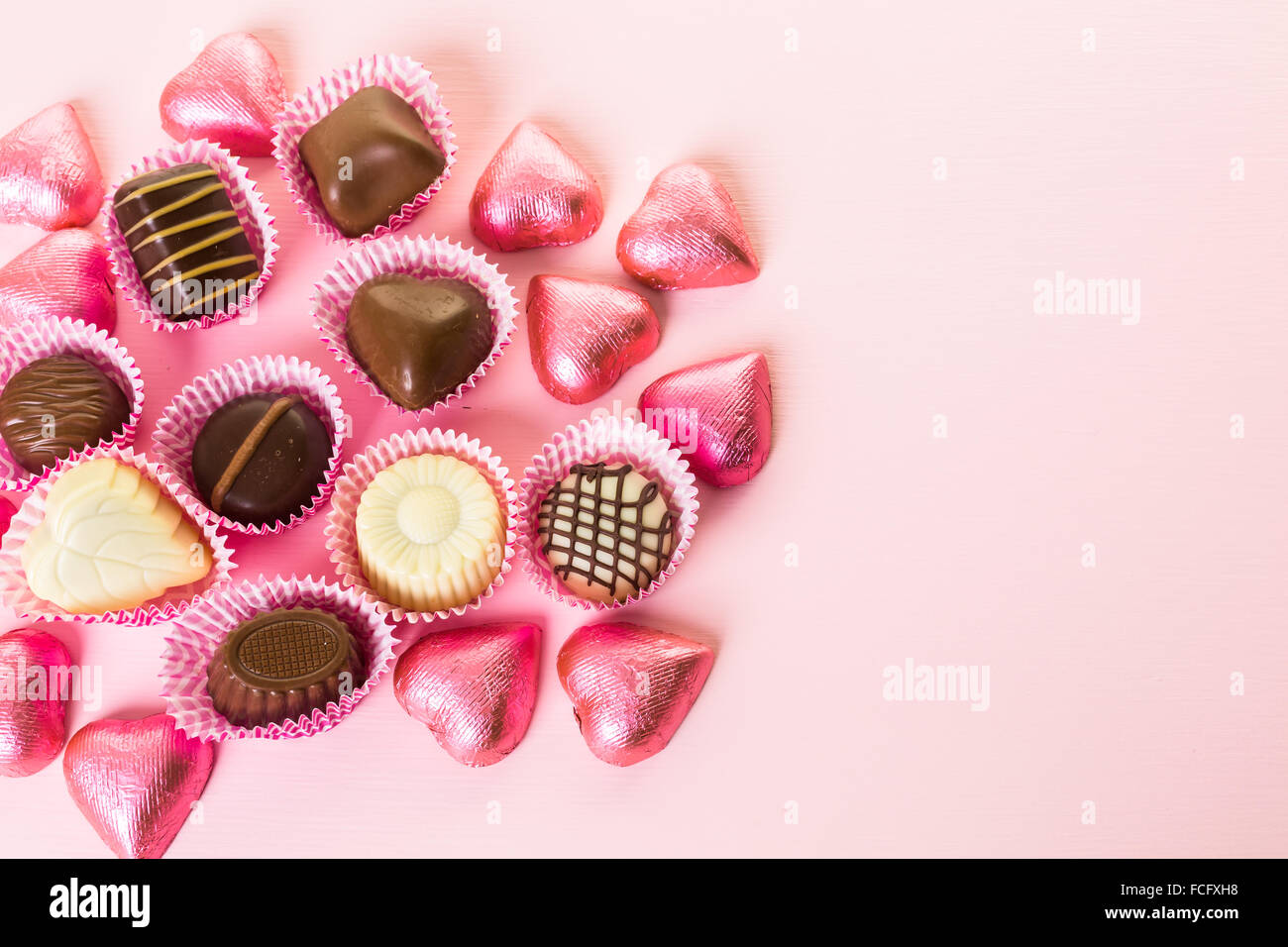 Assorted chocolates on pink background Stock Photo - Alamy