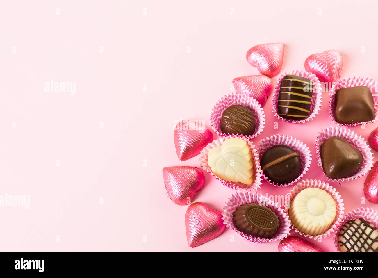 Assorted chocolates on pink background Stock Photo - Alamy