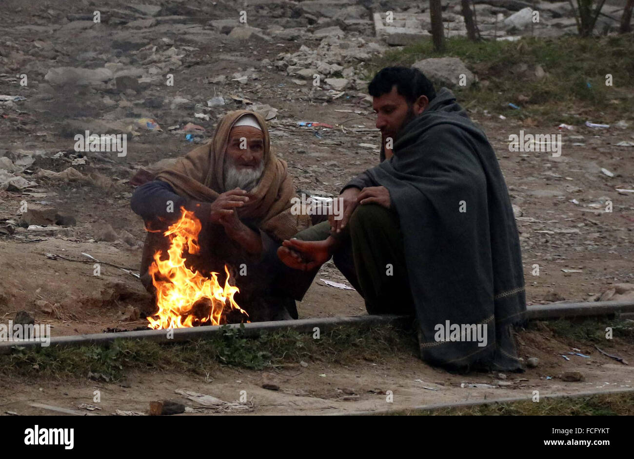 Pakistan. 22nd January, 2016. men warming themselves by burning fire to ...