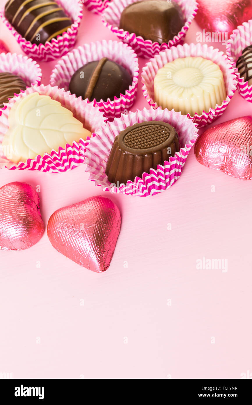 Assorted chocolates on pink background Stock Photo - Alamy