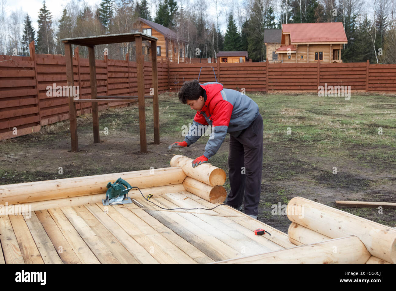 man builds a structure made of logs Stock Photo - Alamy