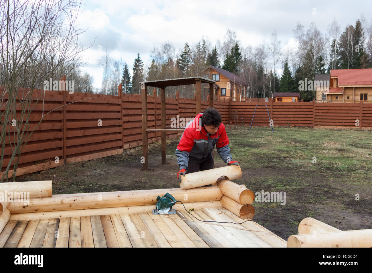 man builds a structure made of logs Stock Photo - Alamy