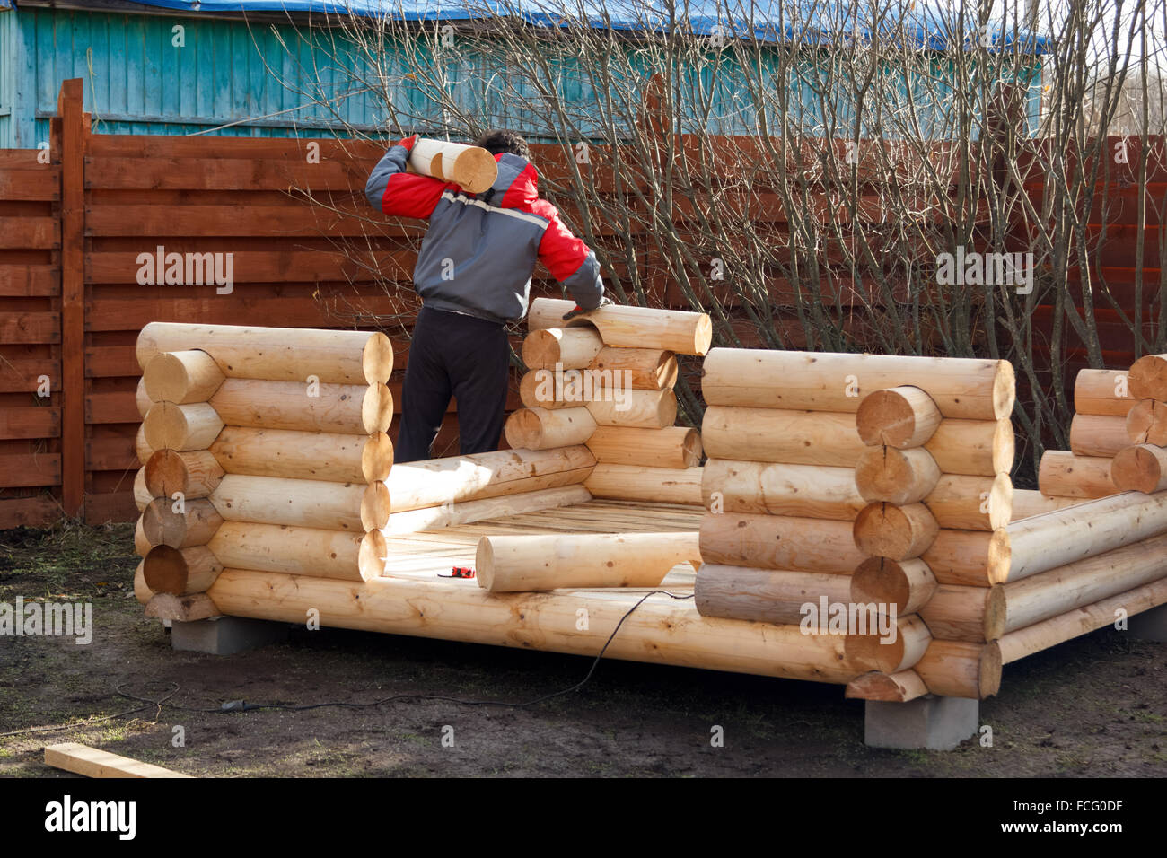 man builds a structure made of logs Stock Photo - Alamy