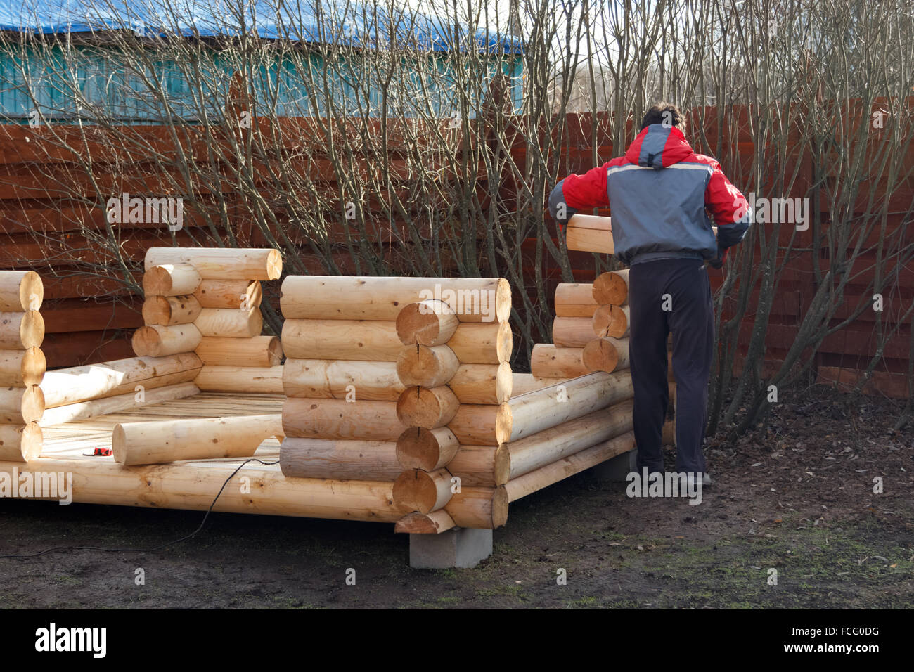 man builds a structure made of logs Stock Photo - Alamy