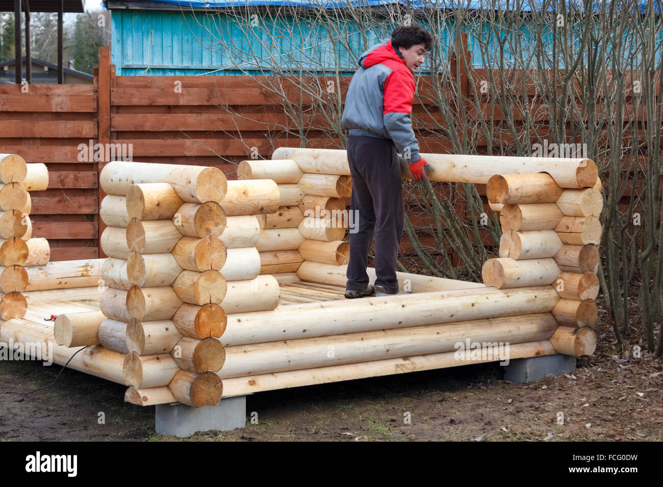 man builds a structure made of logs Stock Photo - Alamy