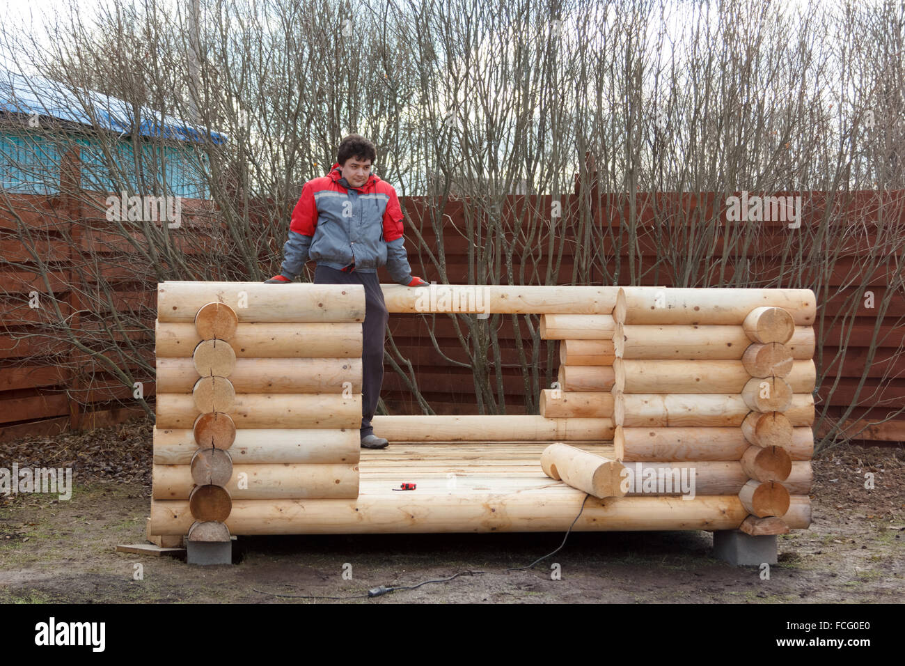 man builds a structure made of logs Stock Photo - Alamy