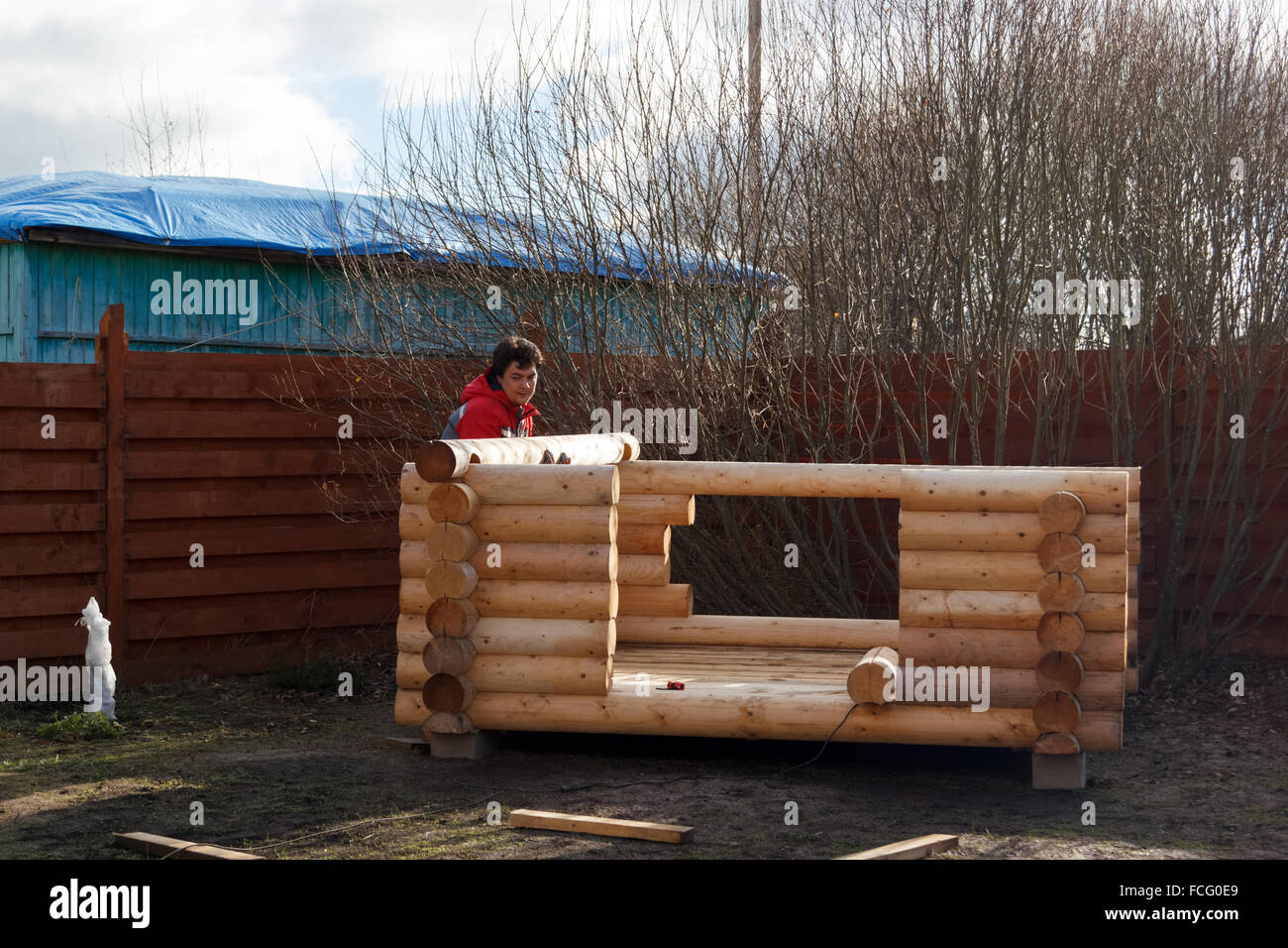 man builds a structure made of logs Stock Photo - Alamy