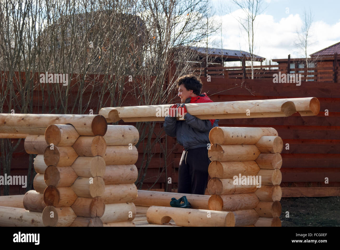 man builds a structure made of logs Stock Photo - Alamy