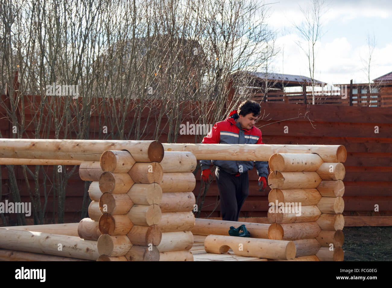 man builds a structure made of logs Stock Photo - Alamy
