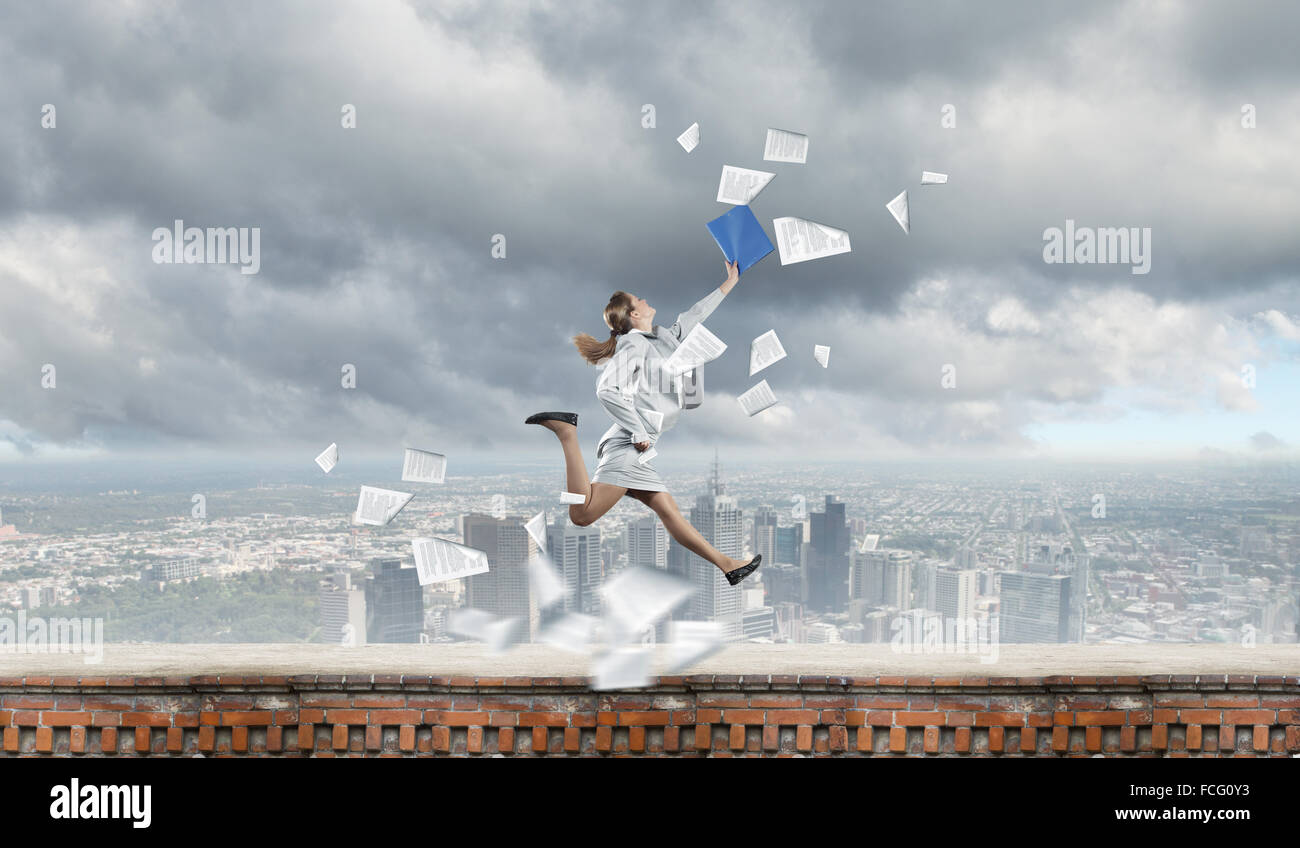 Young happy businesswoman with folder in hand jumping cheerfully Stock ...
