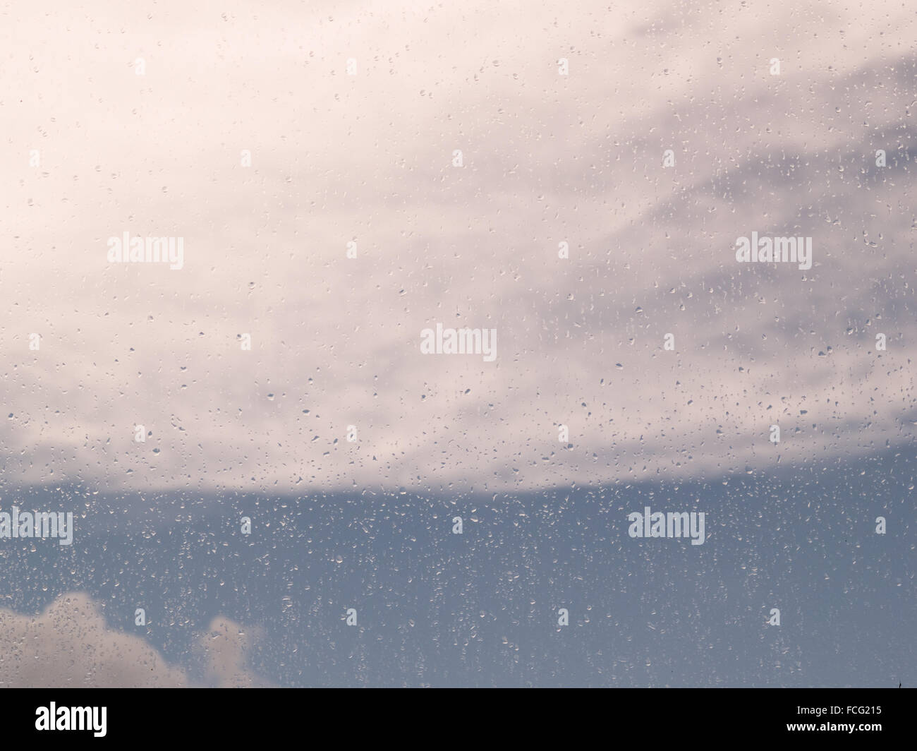 Rain drops on window looking out at blue sky with clouds Stock Photo ...