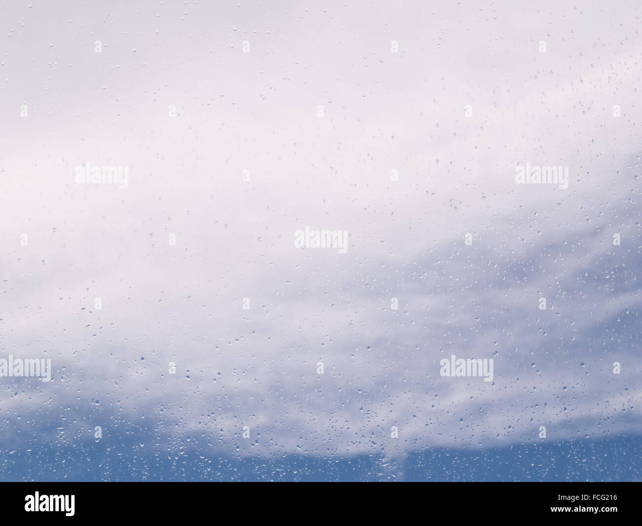 Rain drops on window looking out at blue sky with clouds Stock Photo ...