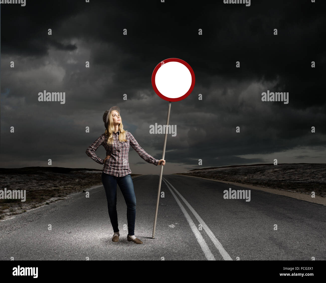 Young woman in casual holding road sign Stock Photo - Alamy