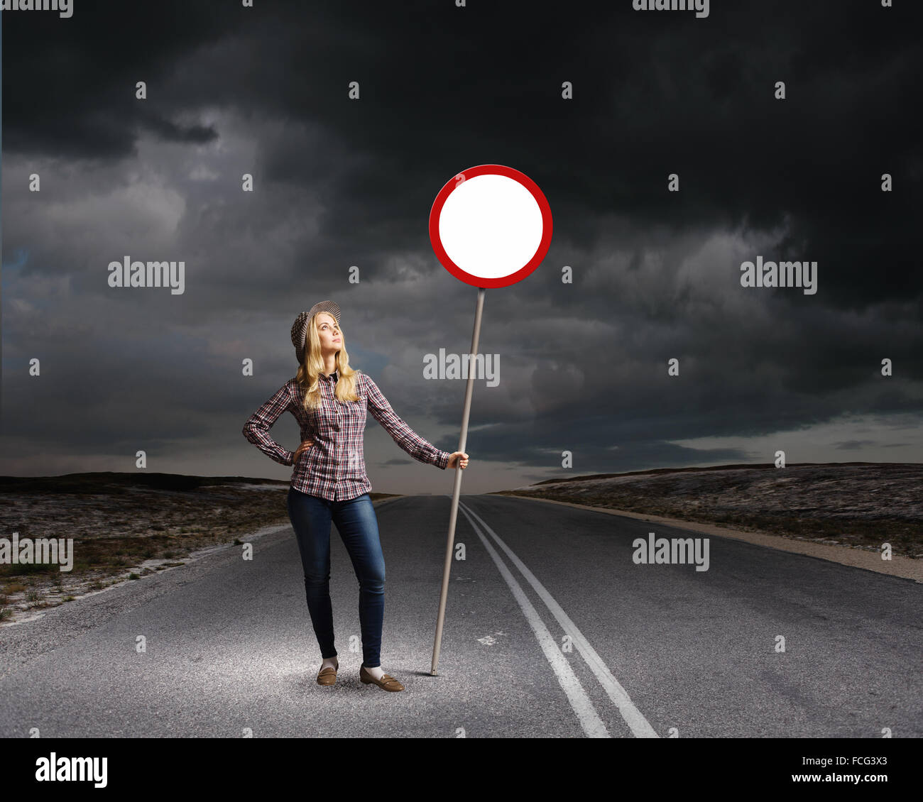Young woman in casual holding road sign Stock Photo - Alamy