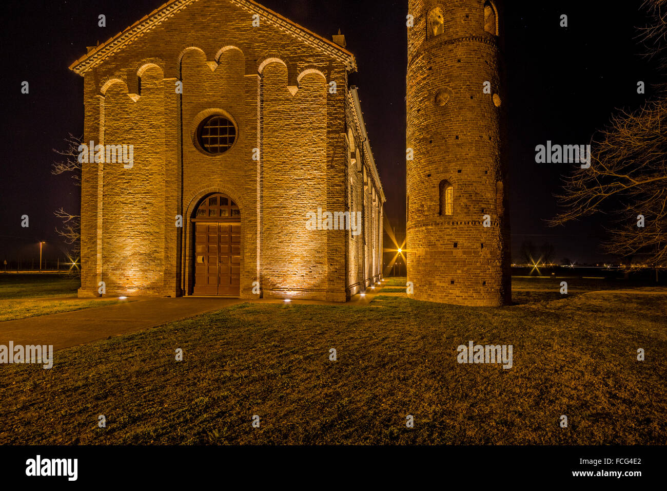 night view of the brick walls of an old Catholic church with one of the ...