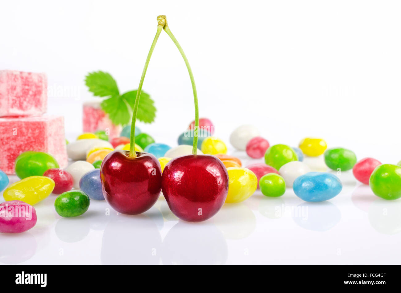 Red cherry, and multicolored dragees Stock Photo - Alamy