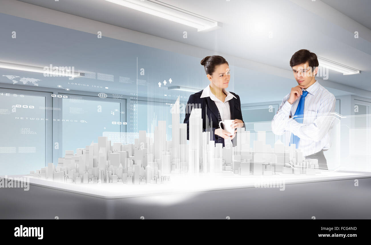 Two young businesspeople looking at construction project Stock Photo ...