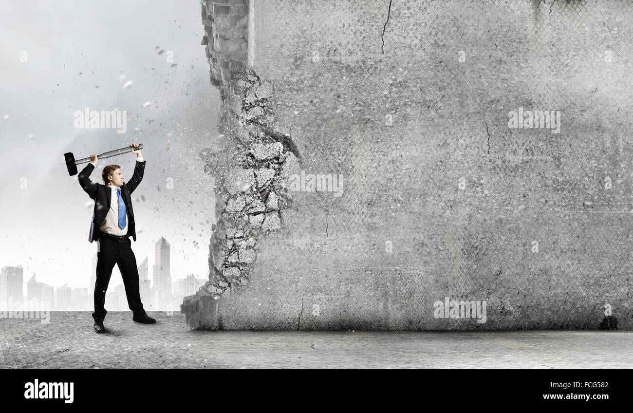 Young businessman breaking cement wall with hammer Stock Photo - Alamy