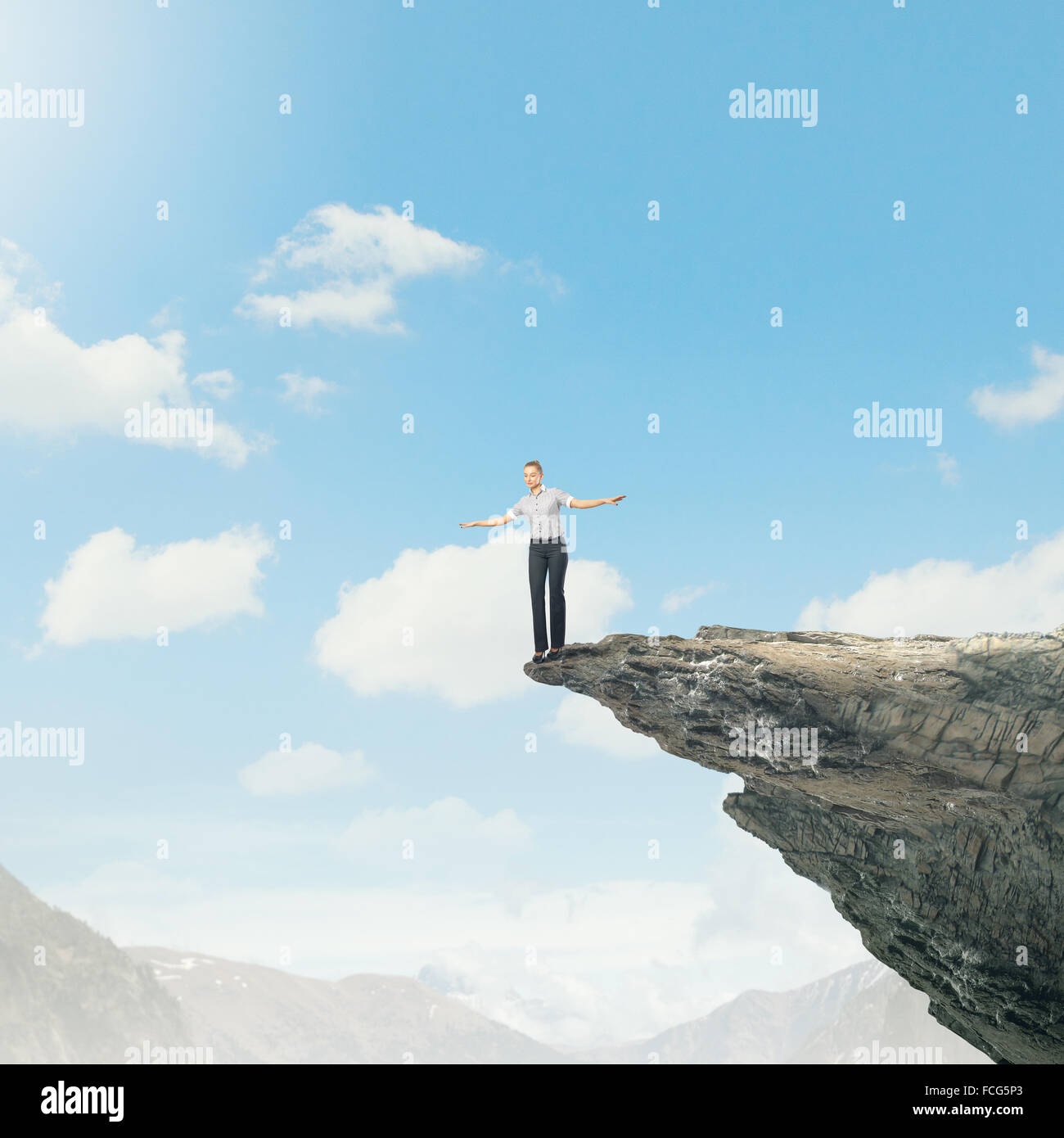 Young businesswoman balancing on edge of hill top Stock Photo - Alamy