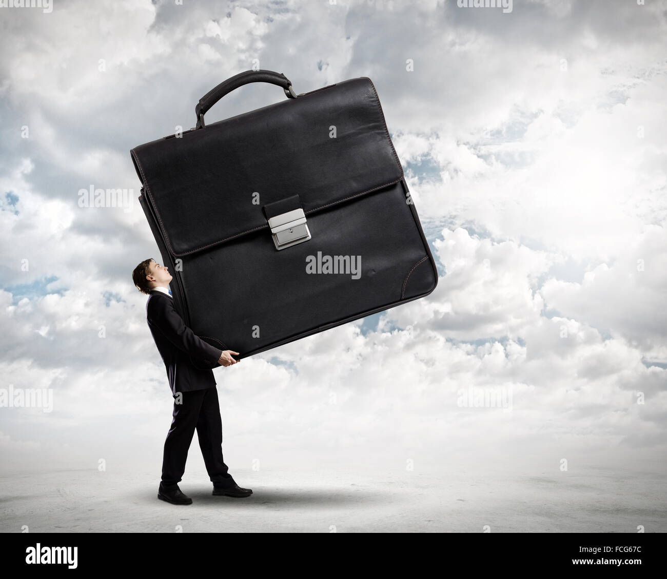 Young determined businessman carrying big heavy suitcase Stock Photo ...
